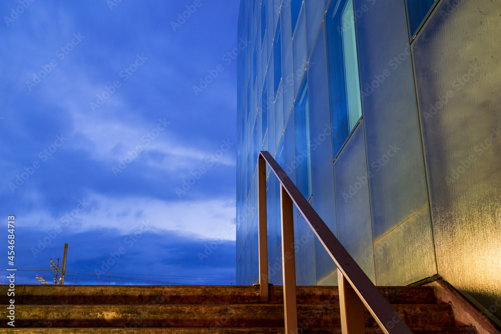 Modern architecture in cold blue light of twilight hour and warm light ...