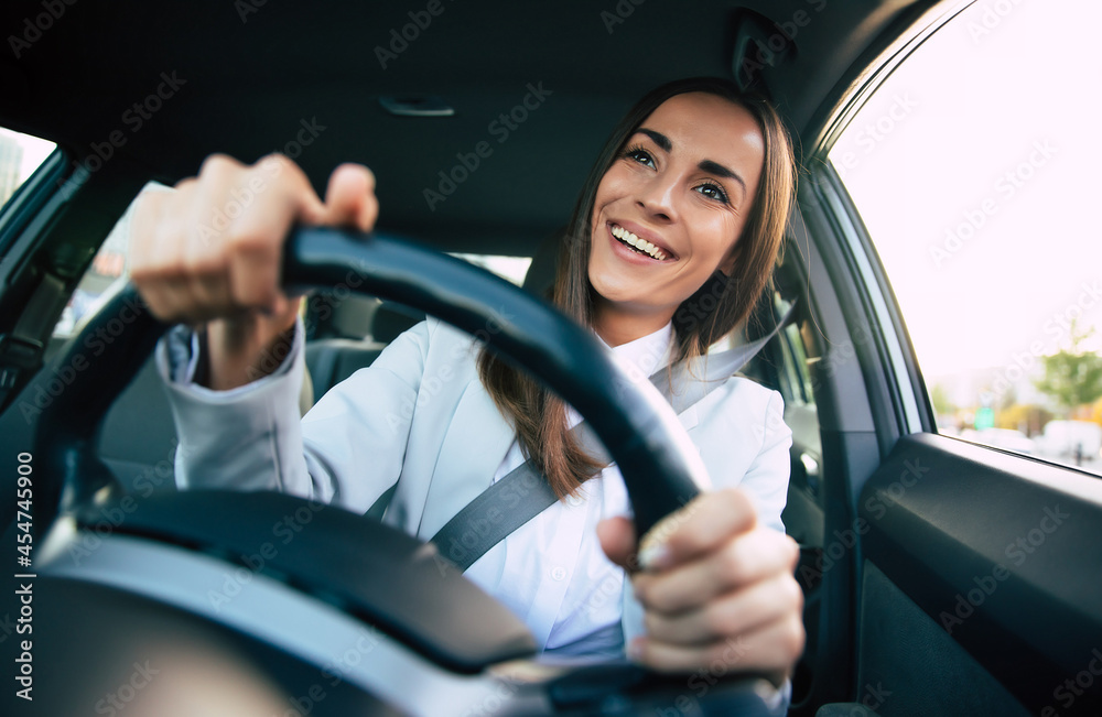 Beautiful happy successful businesswoman is driving a new modern car in ...
