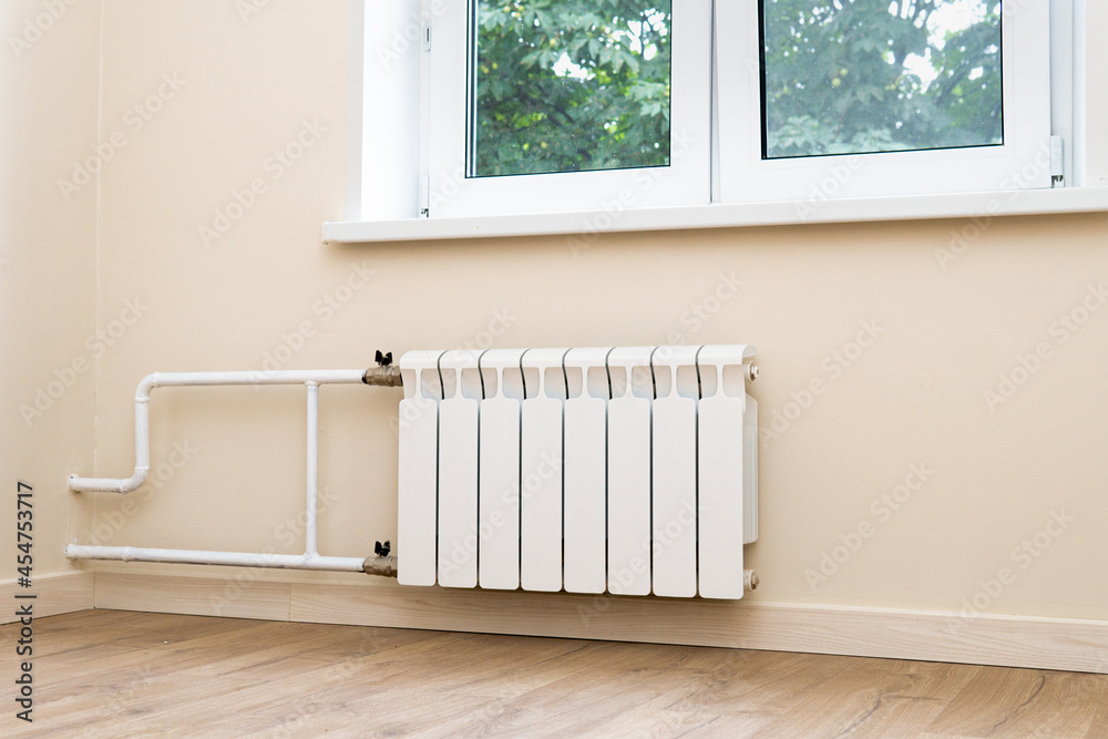 Modern central water heating radiator attached to the wall under the ...
