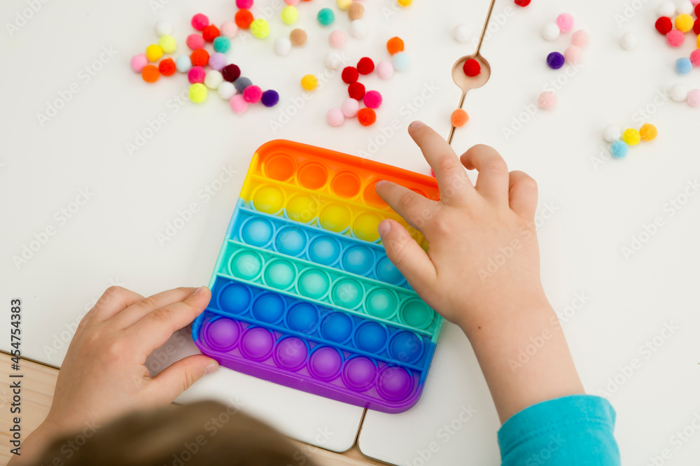 Child plays with sensory fidget toy Pop-it. Instrument for fine motoric ...