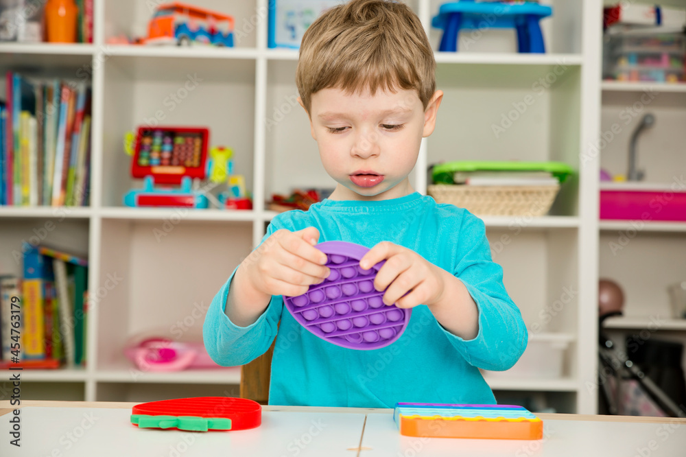 Child plays with sensory fidget toy Pop-it. Instrument for fine motoric ...