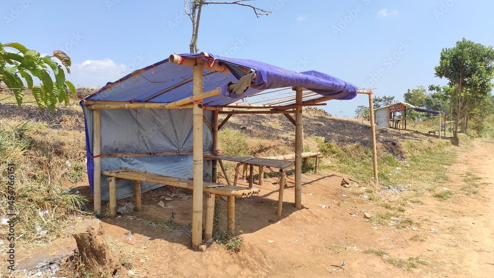 photo of a simple hut made of bamboo and used tarpaulin that serves as ...