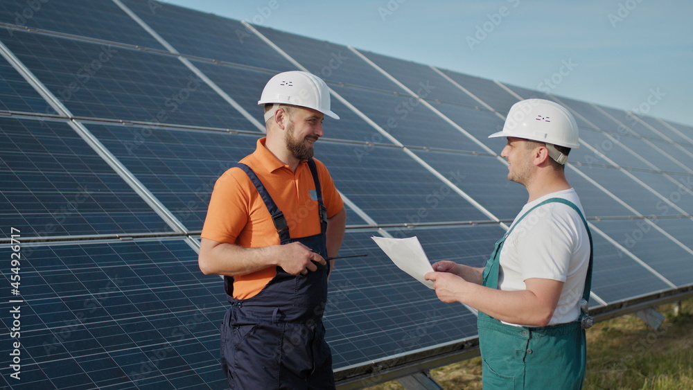 Technician of energy checking the solar cell panels at solar farm ...