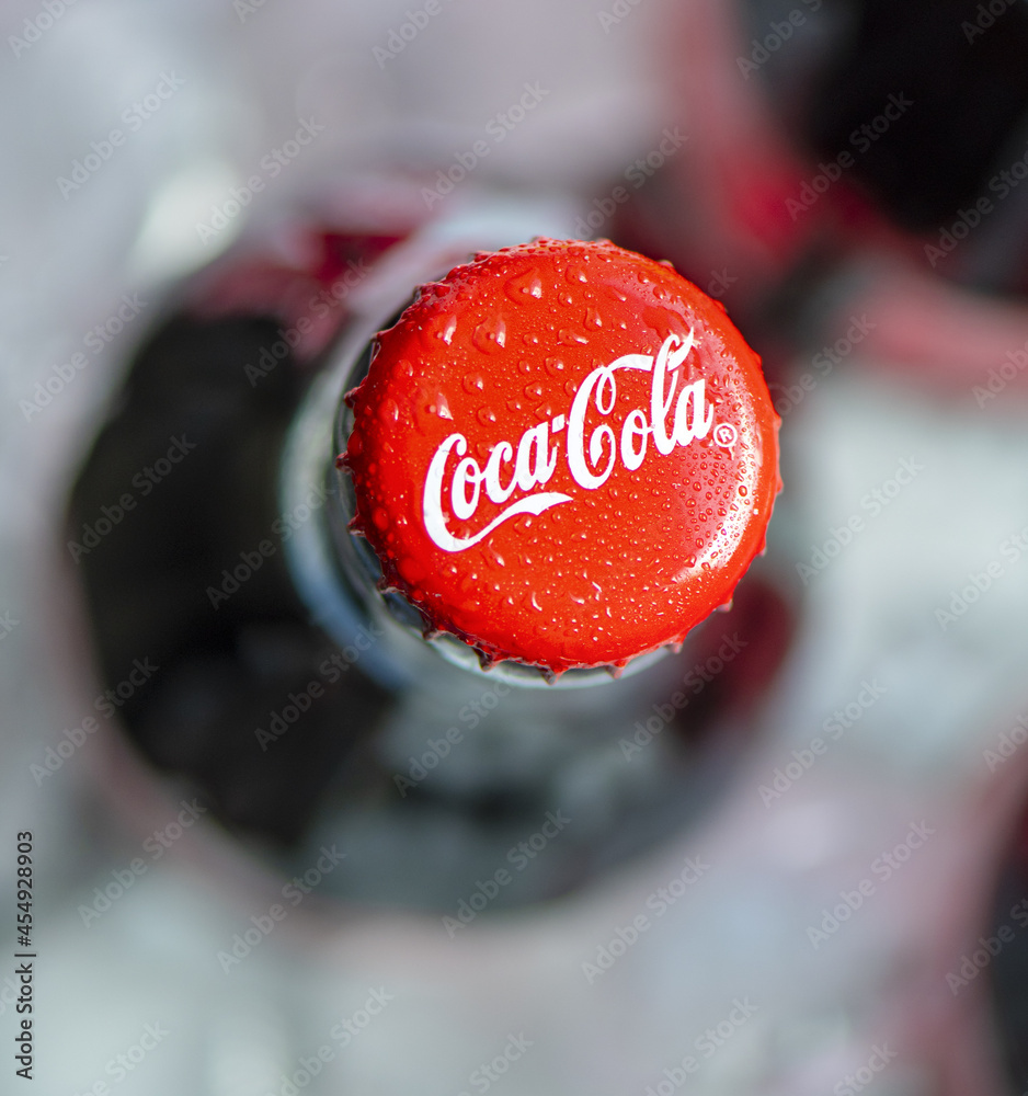 A bottle of Coca-Cola with a closed lid in ice, droplets of moisture ...
