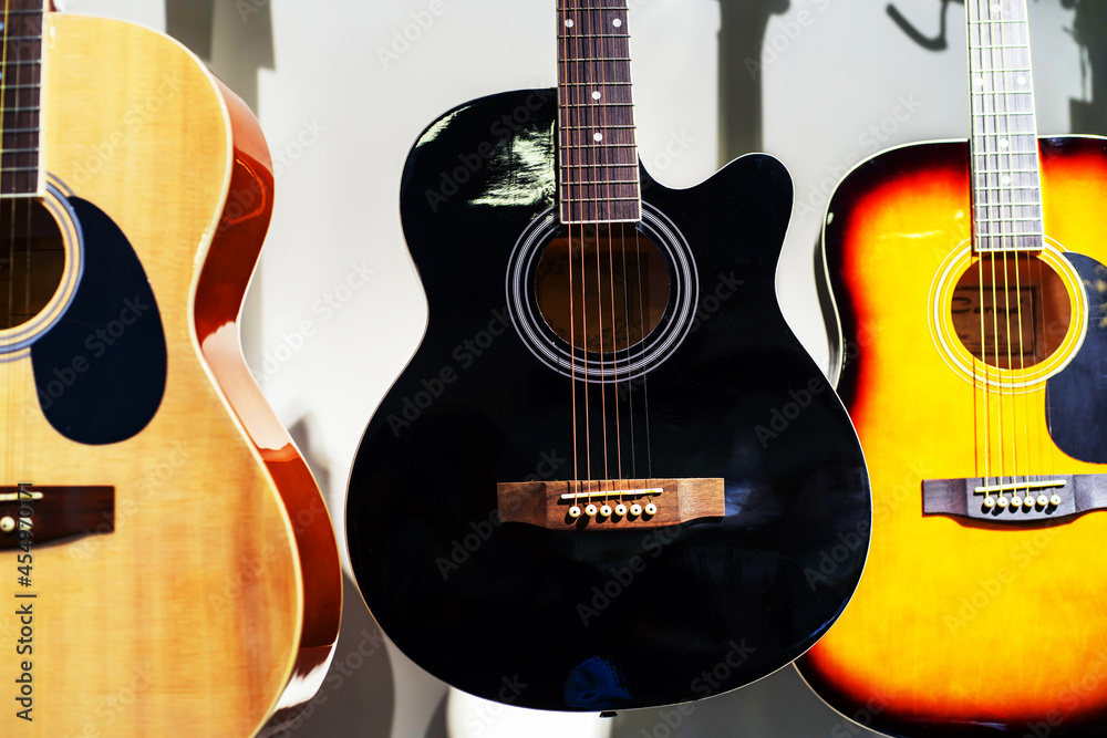 Six-string acoustic guitars on a shop window. An assortment of musical ...