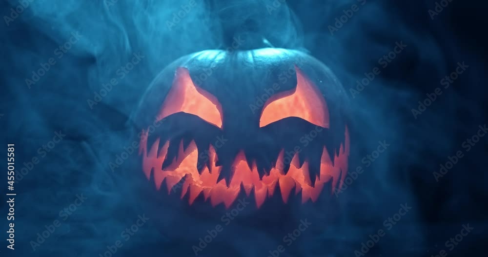 Spooky Halloween jack o lantern with glowing scary face carved out of a ...
