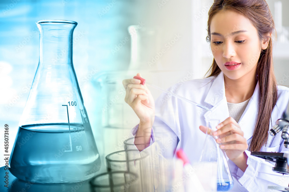 Attractive scientist woman looking chemical sample in flask at ...