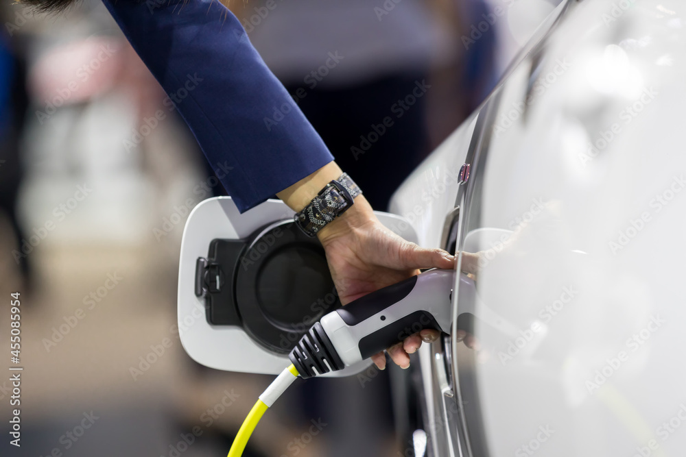 Hand holding Electric car charger. Electric Vehicle EV Charging station ...