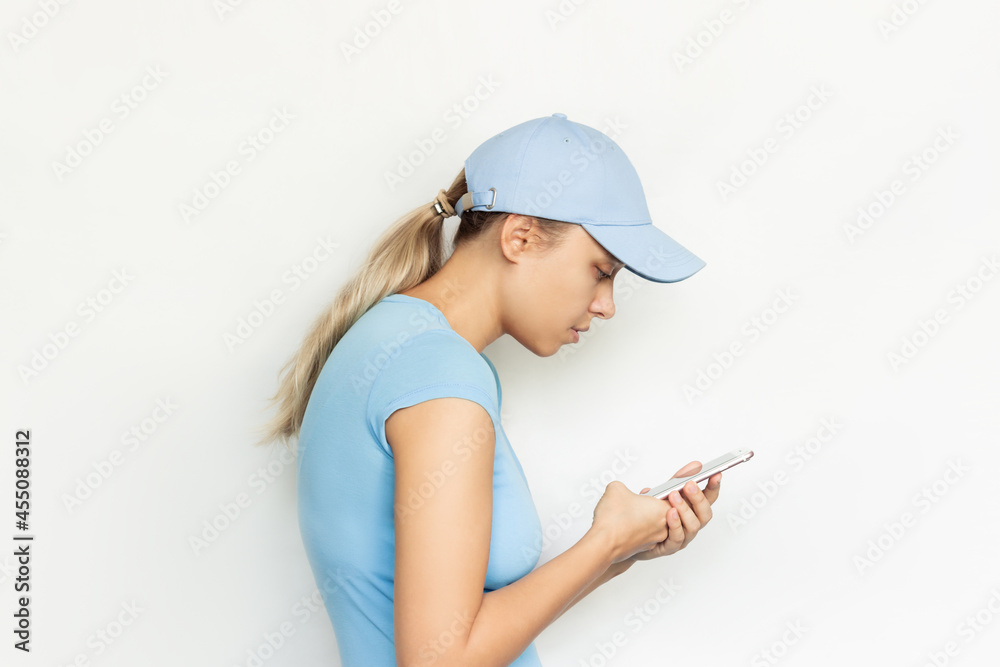 A young blonde woman in a blue cap with a hunched back looks at the ...