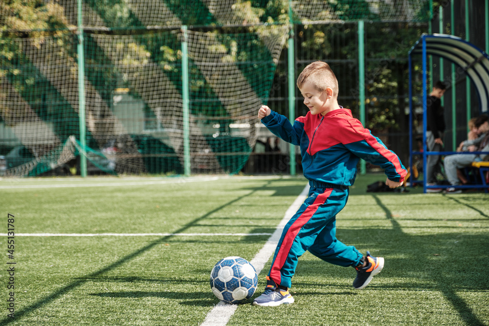 Schoolboy playing football on the Playground. Moment of hitting the ...