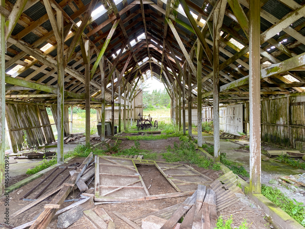 interior of a torn down farm barn building structure with discarded ...