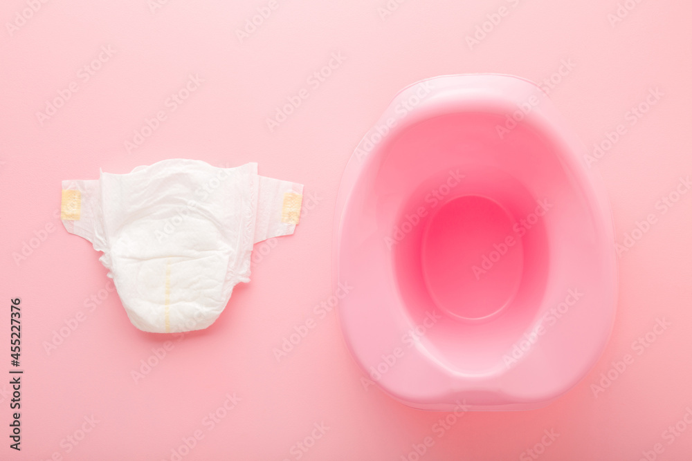 Baby potty and white soft nappy on light pink table background. Pastel ...