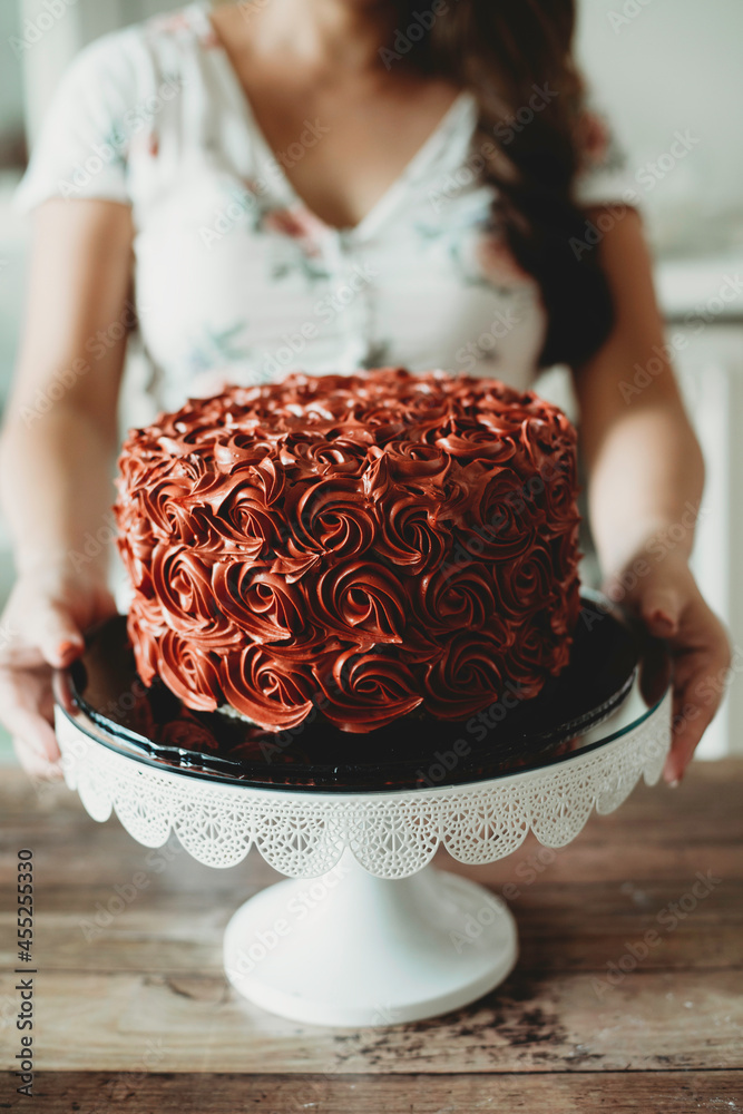 Hands of lady holding a white stand with red velvet birthday cake.Woman ...