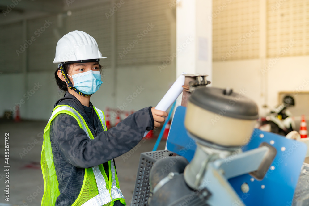 Young Asian female engineer wearing a medical mask to cover her mouth ...