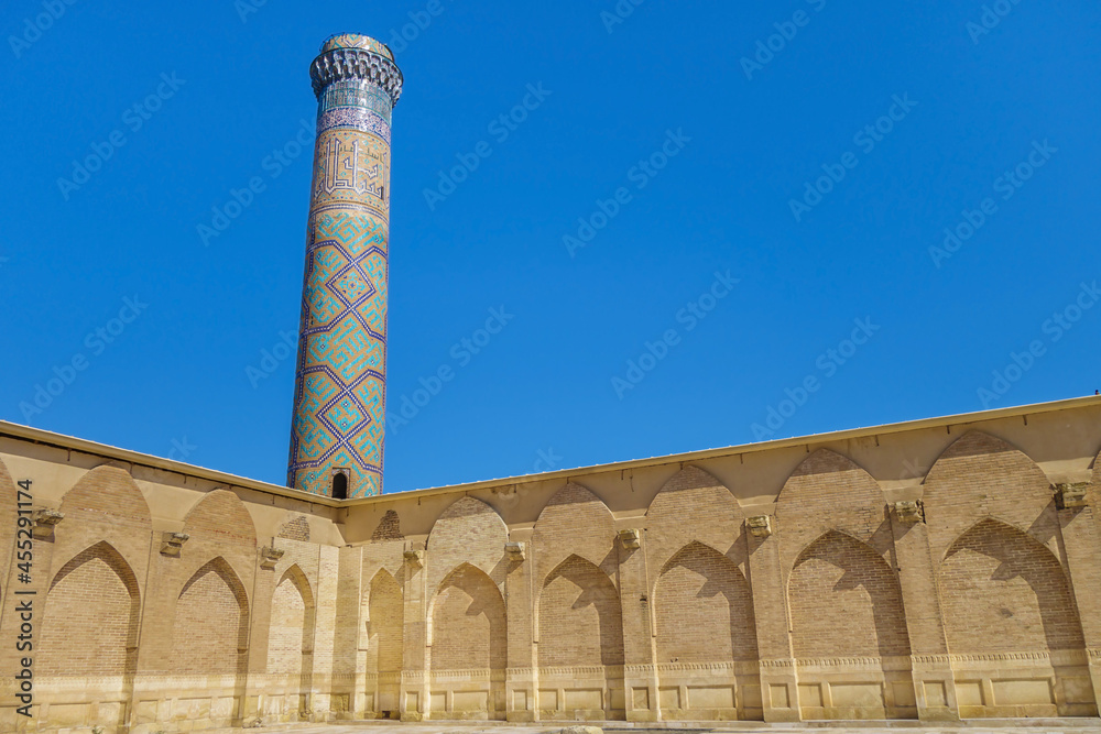 Minaret and wall of Bibi Khanym mosque against background of blue sky ...