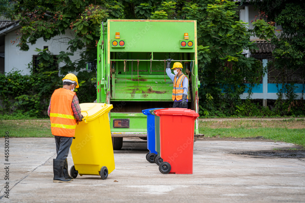 Worker of recycling garbage collector truck loading waste and trash bin ...