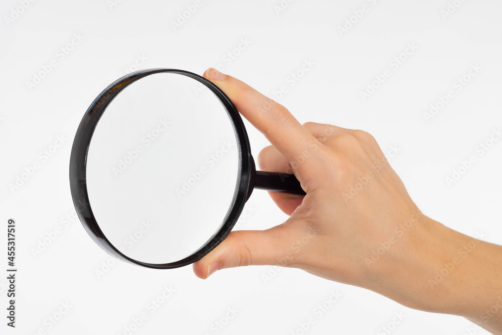 Hand with a magnifying glass isolated on white. Studying under a ...