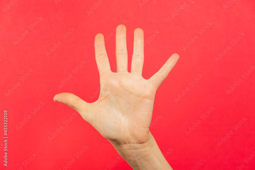 Mano numero 5, señal numero 5, fondo rojo. Stock Photo | Adobe Stock