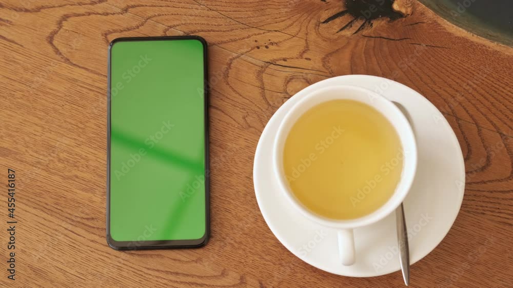 Smartphone place on table wood with green screen, Close-up the cell ...