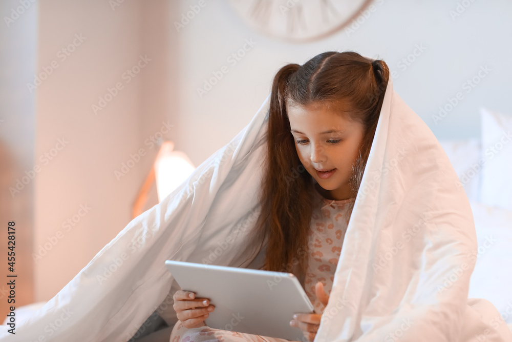 Cute girl watching cartoons in bedroom Stock Photo | Adobe Stock
