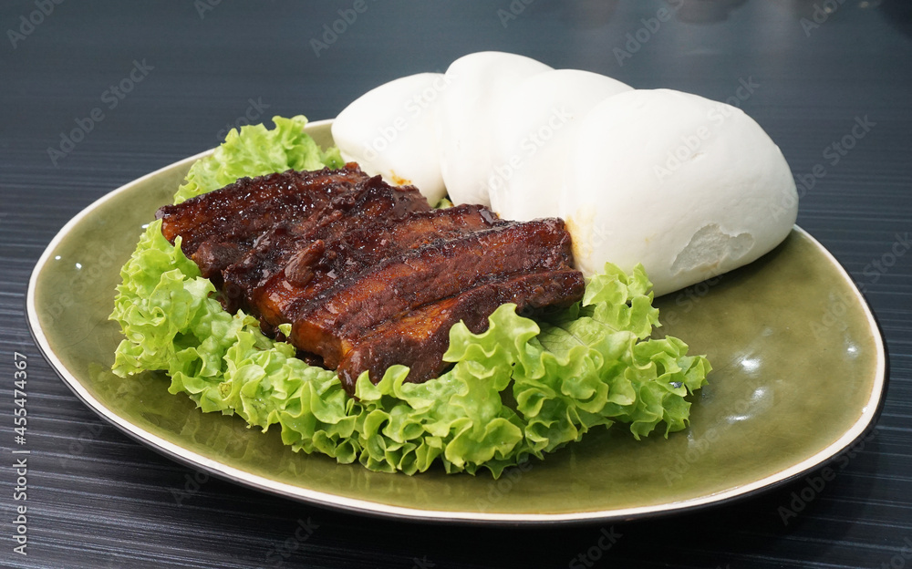 braised pork belly meat wrapped with mantou bun Chinese burger on dark ...
