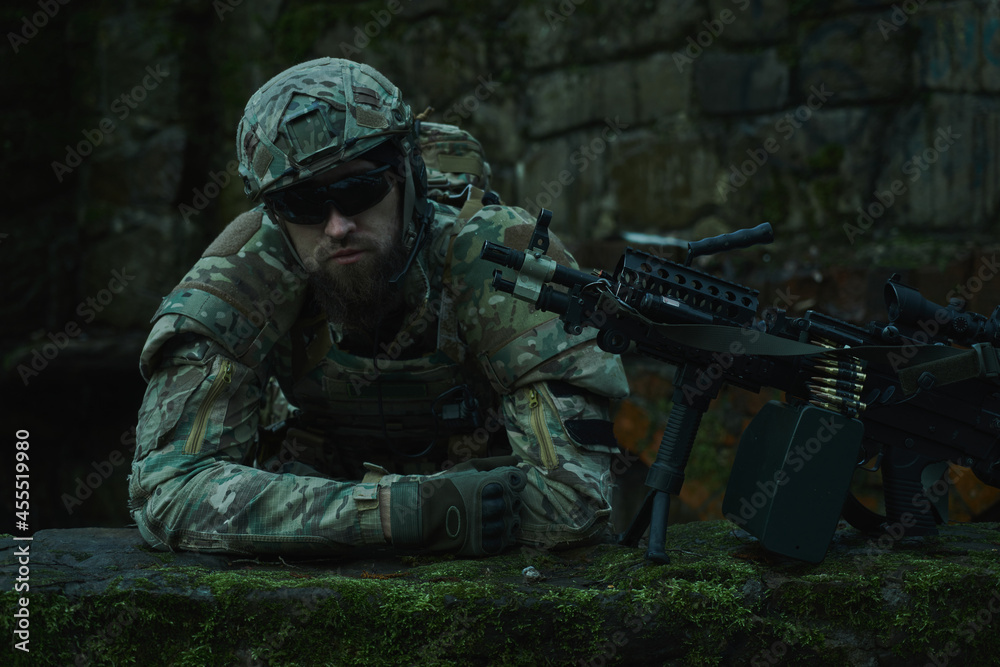 Portrait of airsoft player in professional equipment with machine gun ...