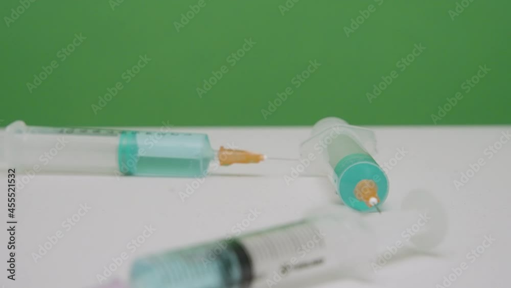 Multiple Medical needle shots on a white table with a green screen in ...