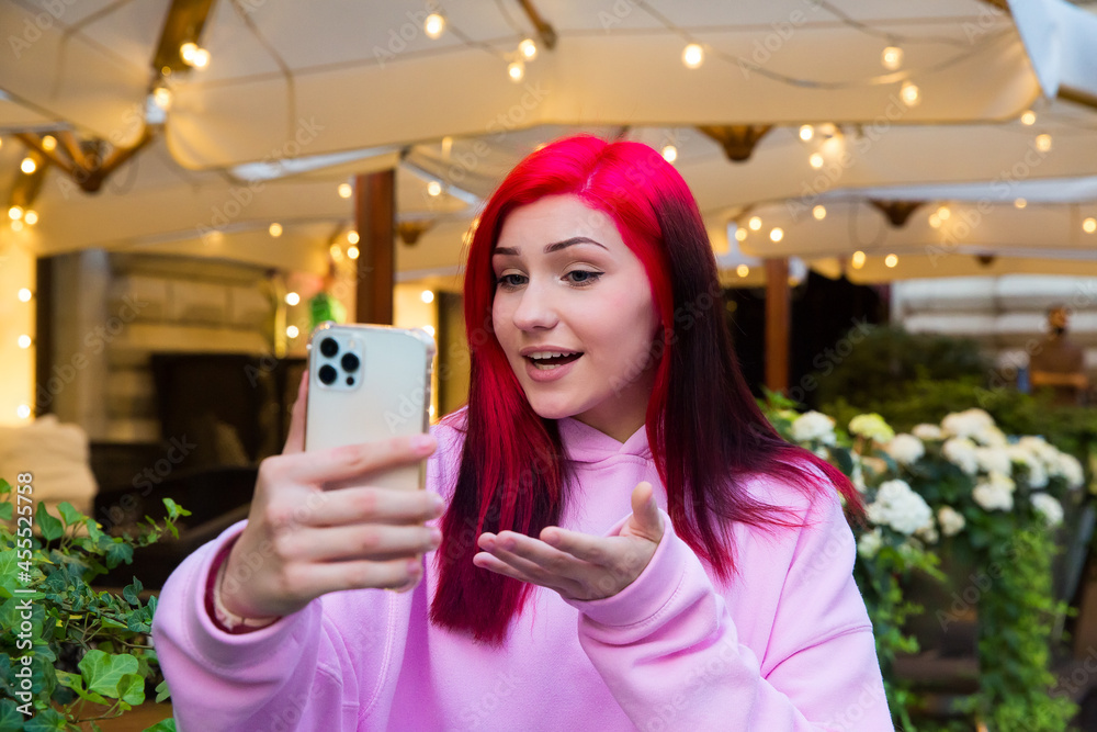 Beautiful red-haired influencer blogger girl in cafe talking making ...