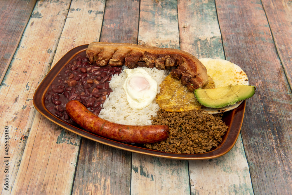 Popular Colombian paisa tray with fried chorizo and chicharron, corn ...