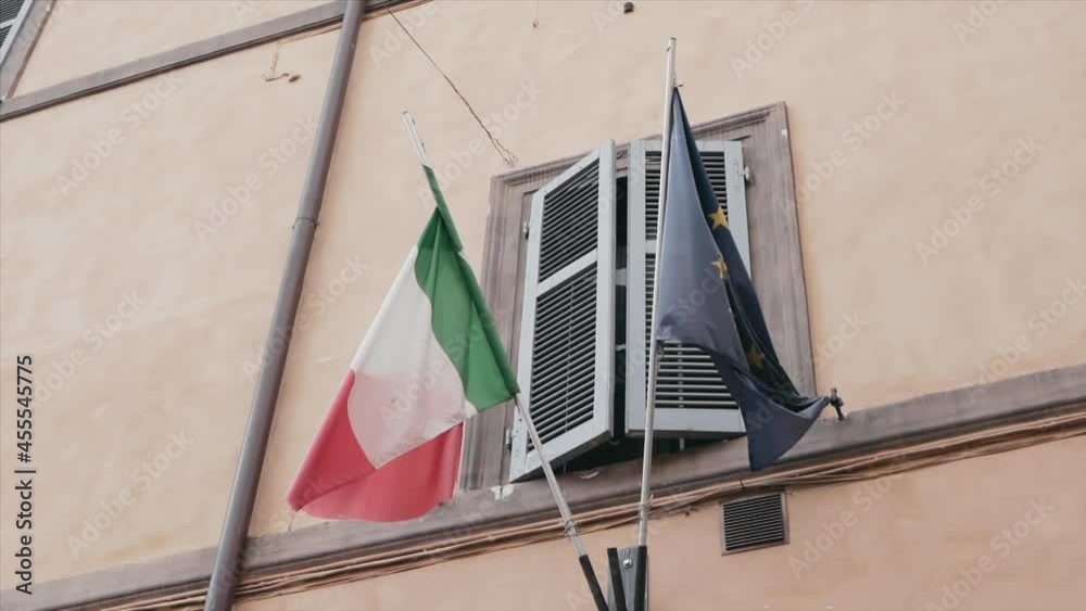 Wideo Stock: Flags of Italy and European Union hanging under the window ...