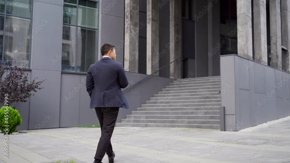 Video Stock rear view of asian businessman go fast on uban background ...