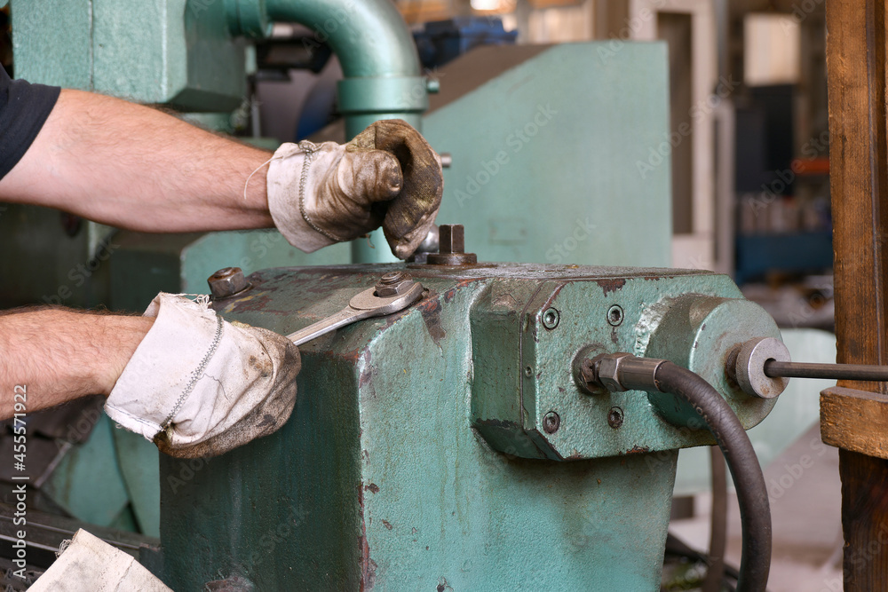 The worker installs the fixture on the machine bed by tightening the ...