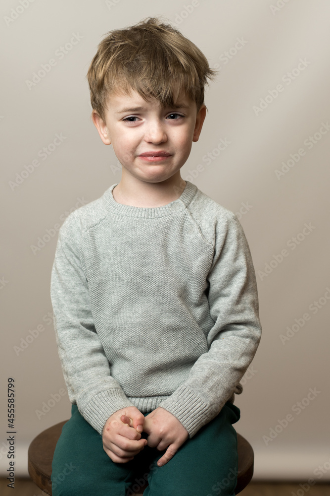 little boy of European appearance with a sad face. the baby is crying ...