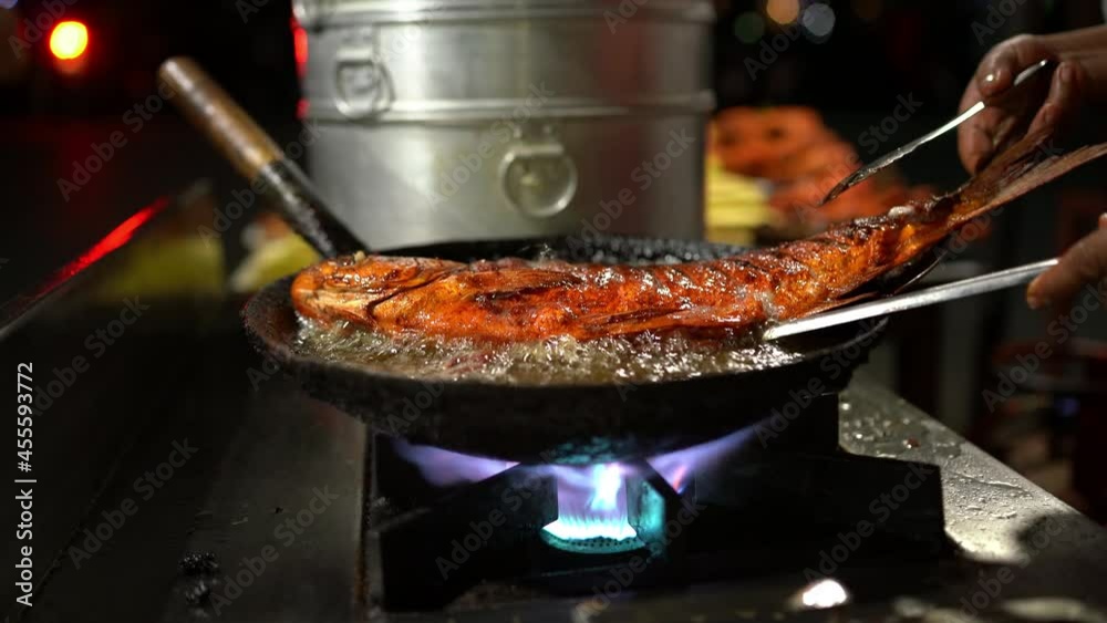 4K close-up footage of red sea fish frying in bubbling oil on gas ...