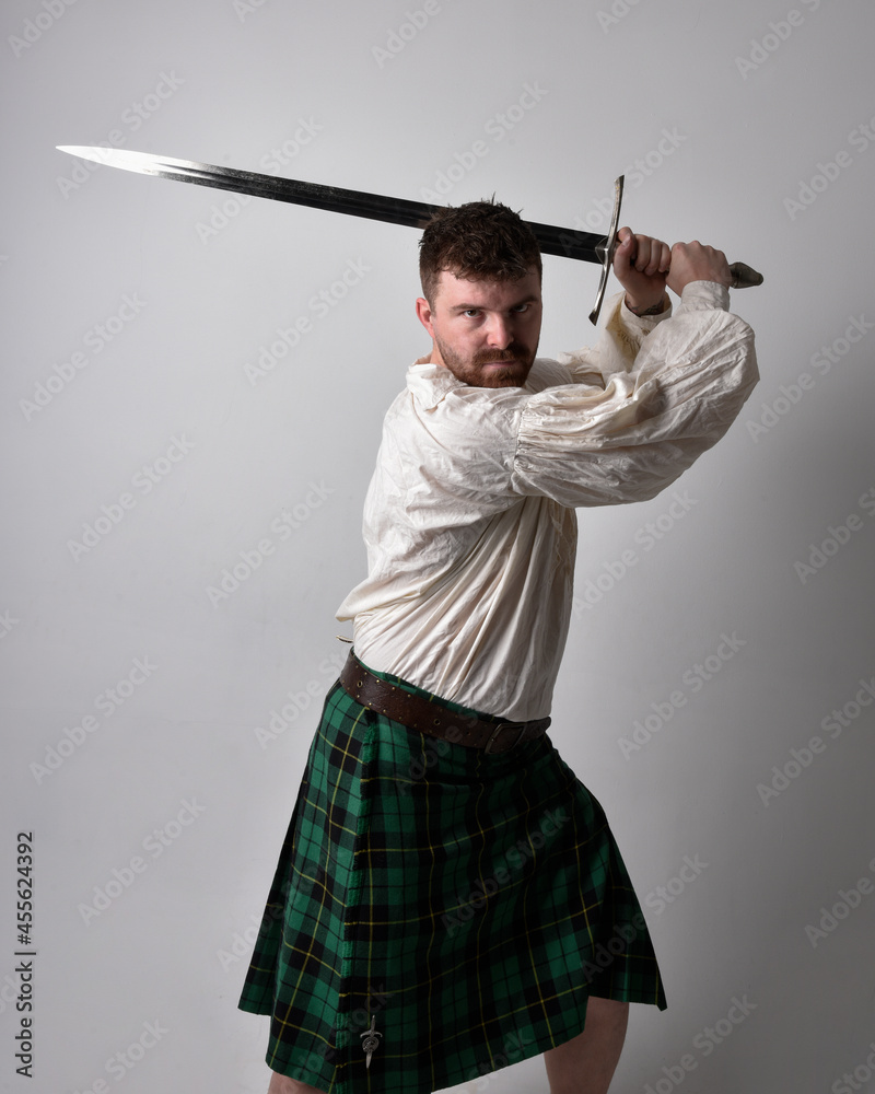 Close up portrait of handsome brunette man wearing Scottish kilt and ...