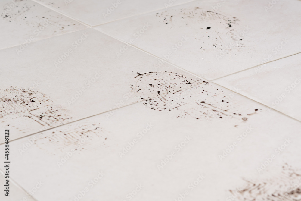 footprints of the sole of shoes on the floor of ceramic tiles, close-up ...