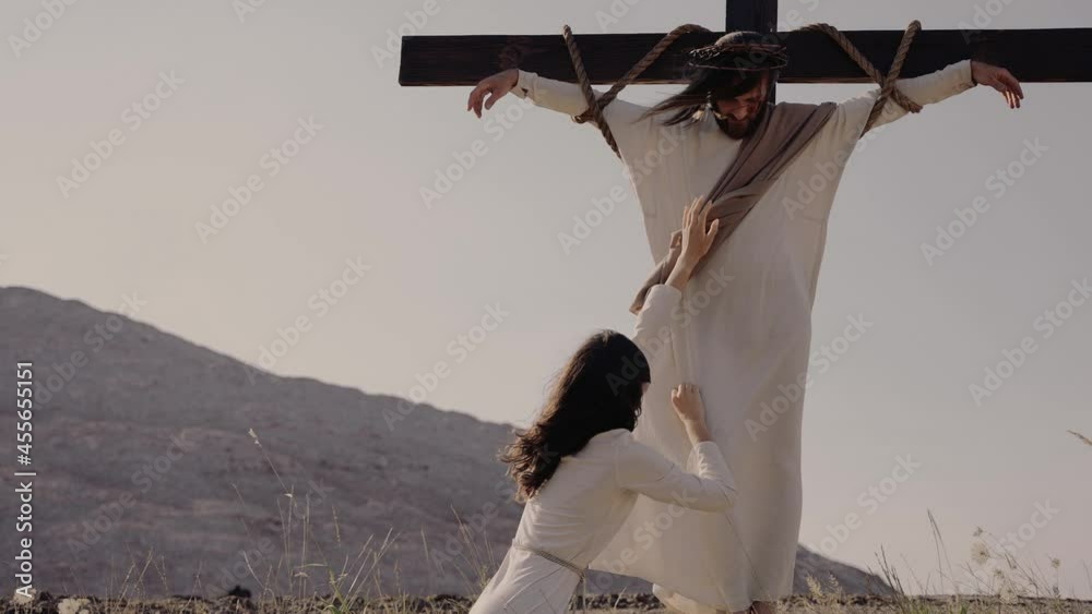 Vidéo Stock Mary mourns the death of Jesus at his feet. Jesus is crucified on the cross. Wind is ...