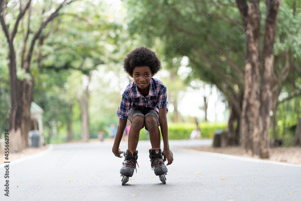 Happy child boy playing on roller blades, African American young boy ...