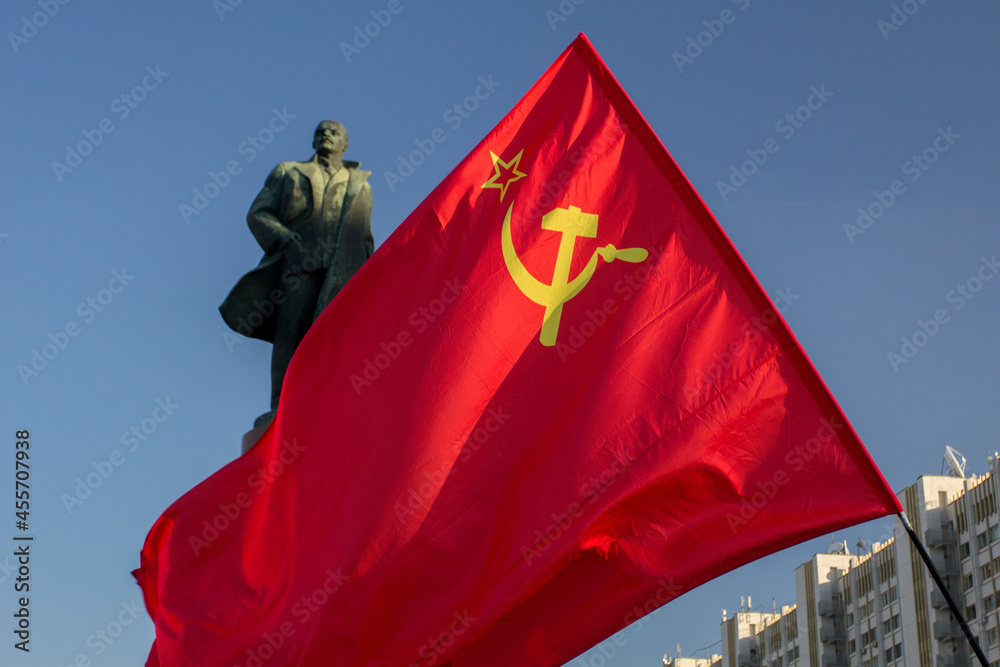 The flag of the Soviet Union (USSR) waving in the wind against the background of the monument to ...