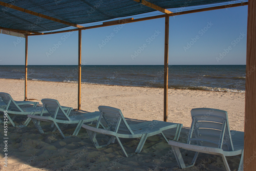 Lounge chairs on the beach. Empty resort. Sun beds under cover on the ...