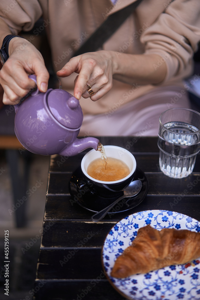 Crop woman pouring tea for breakfast Stock Photo | Adobe Stock