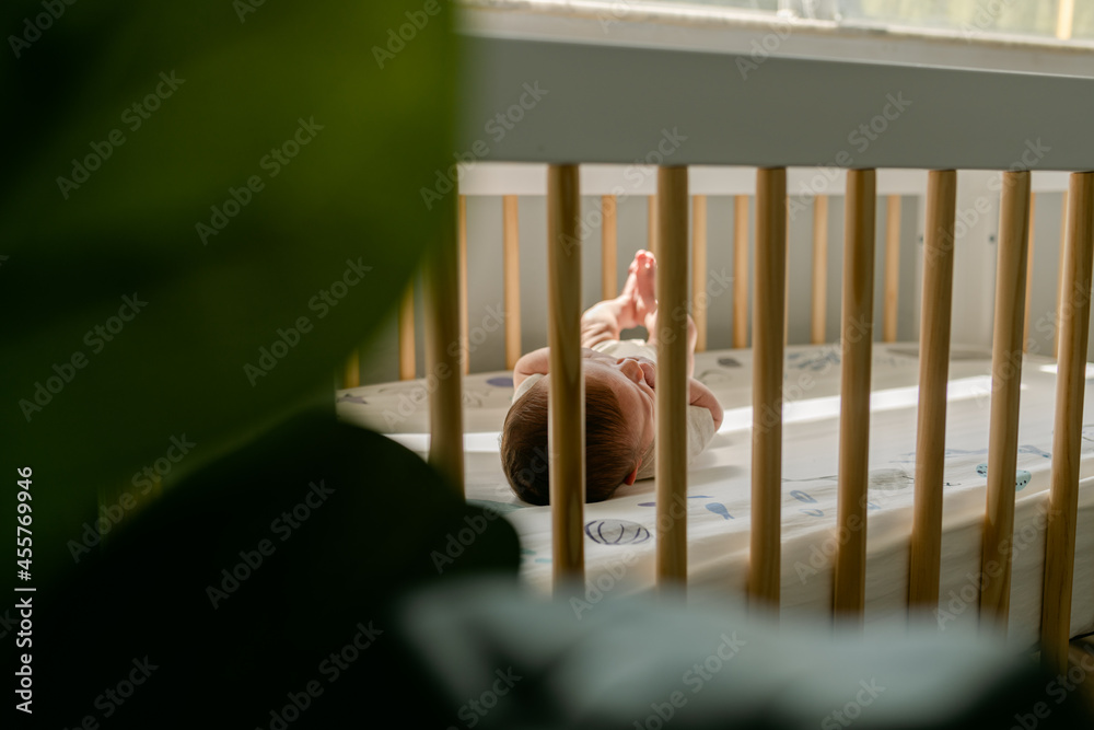 Baby laying alone in his crib Stock Photo | Adobe Stock