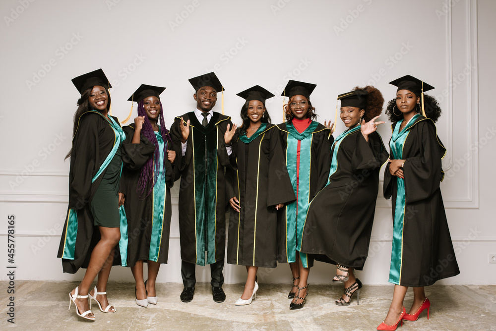 Smiling students posing in the academic dresses Stock Photo | Adobe Stock
