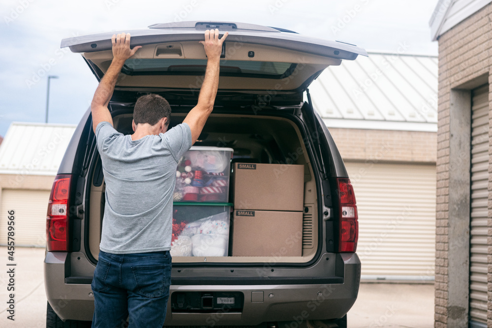 Storage: Man Opens Back Of SUV To Get Box Stock Photo | Adobe Stock