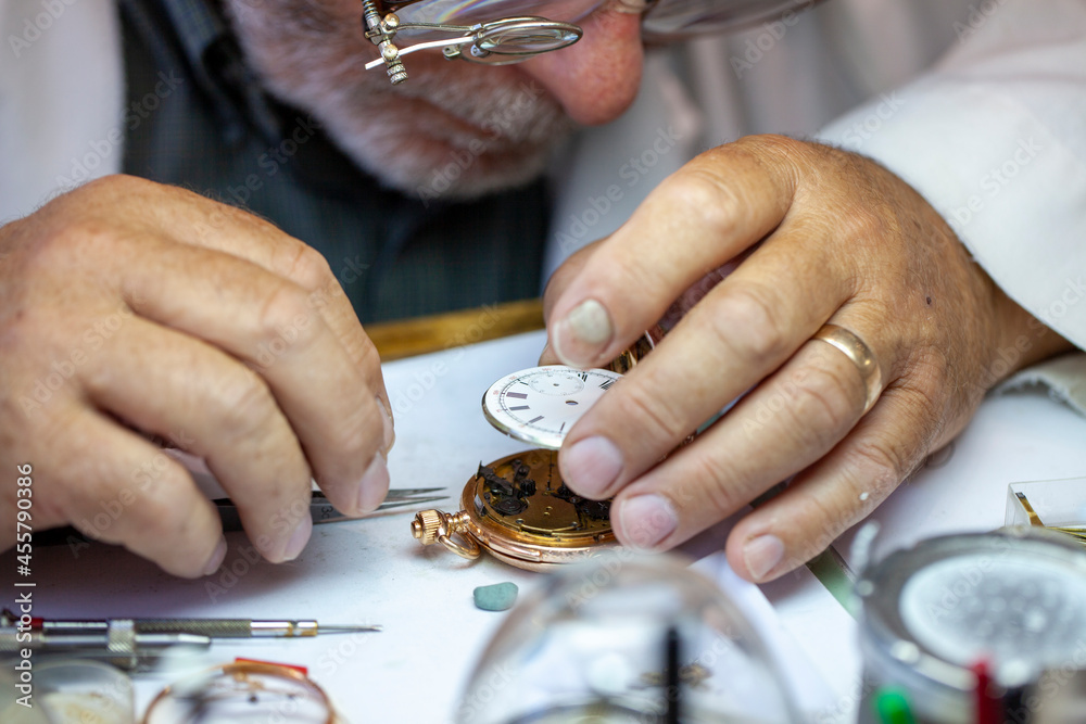 Mature Watchmaker repairing vintage pocket watch and clock on the ...