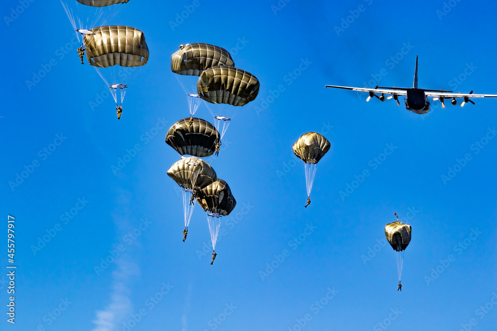 Military parachutist paratroopers parachute jumping out of a air force ...