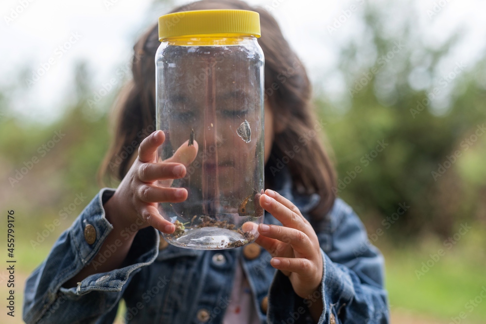 little girl holding a jar with butterflies in Stock Photo | Adobe Stock