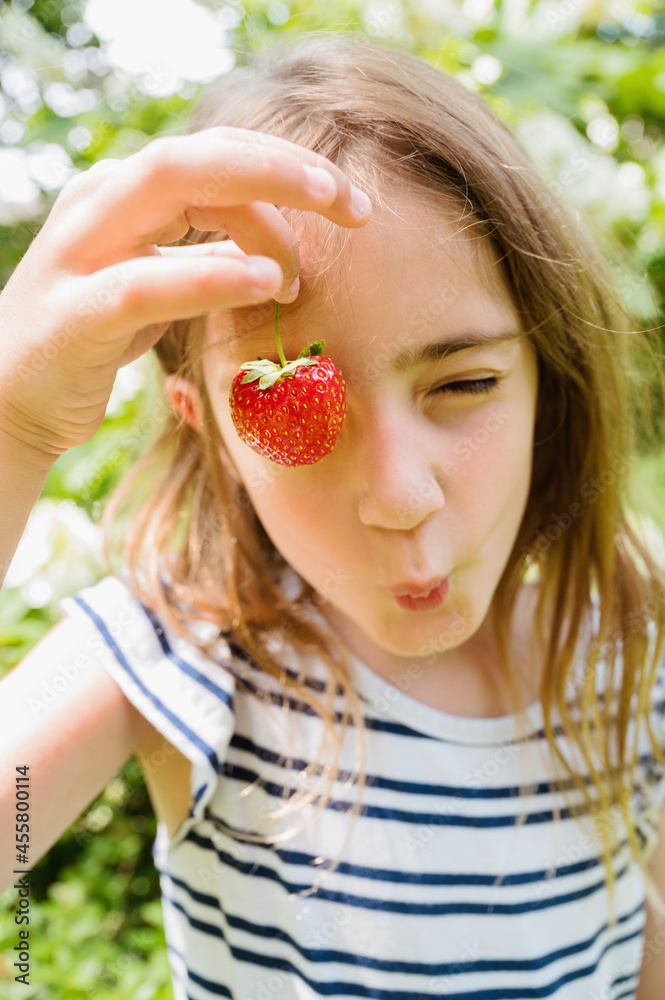 Little Girl Making Silly Face Behind Big Strawberry Stock Photo | Adobe ...