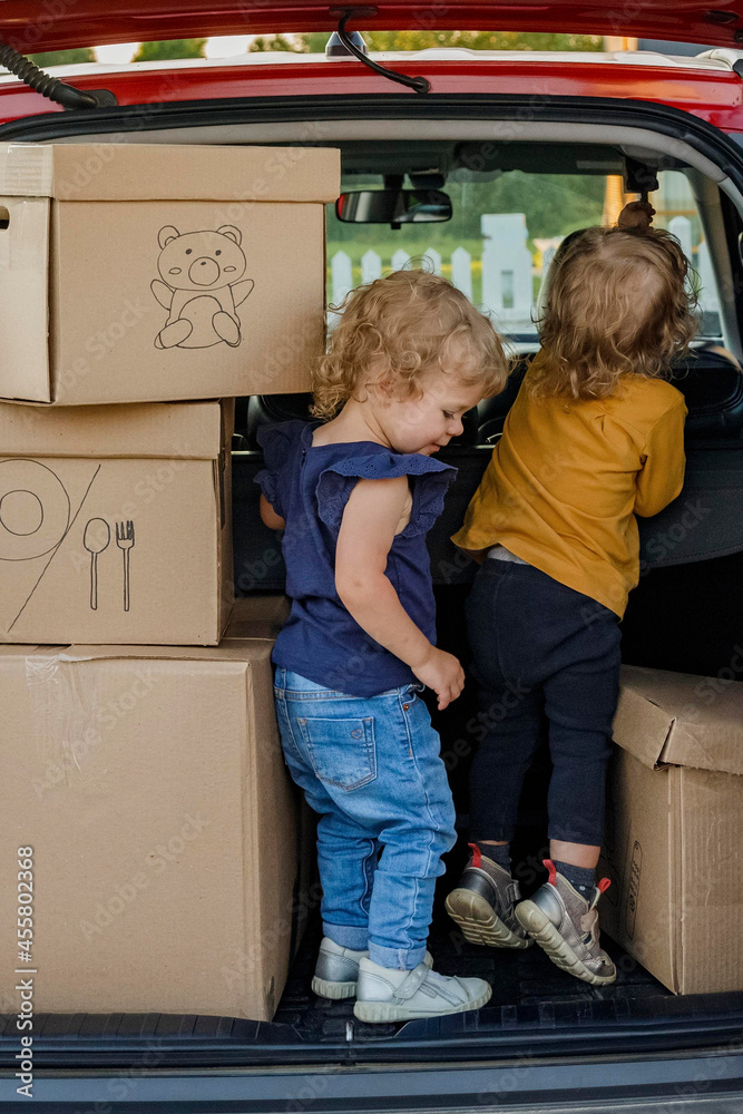 Kids playing near boxes in car trunk Stock Photo | Adobe Stock