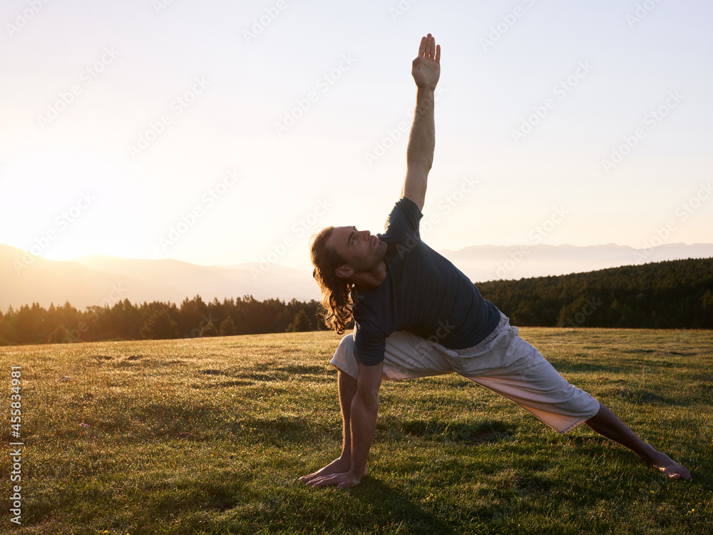 Man in extended triangle pose. Stock Photo | Adobe Stock